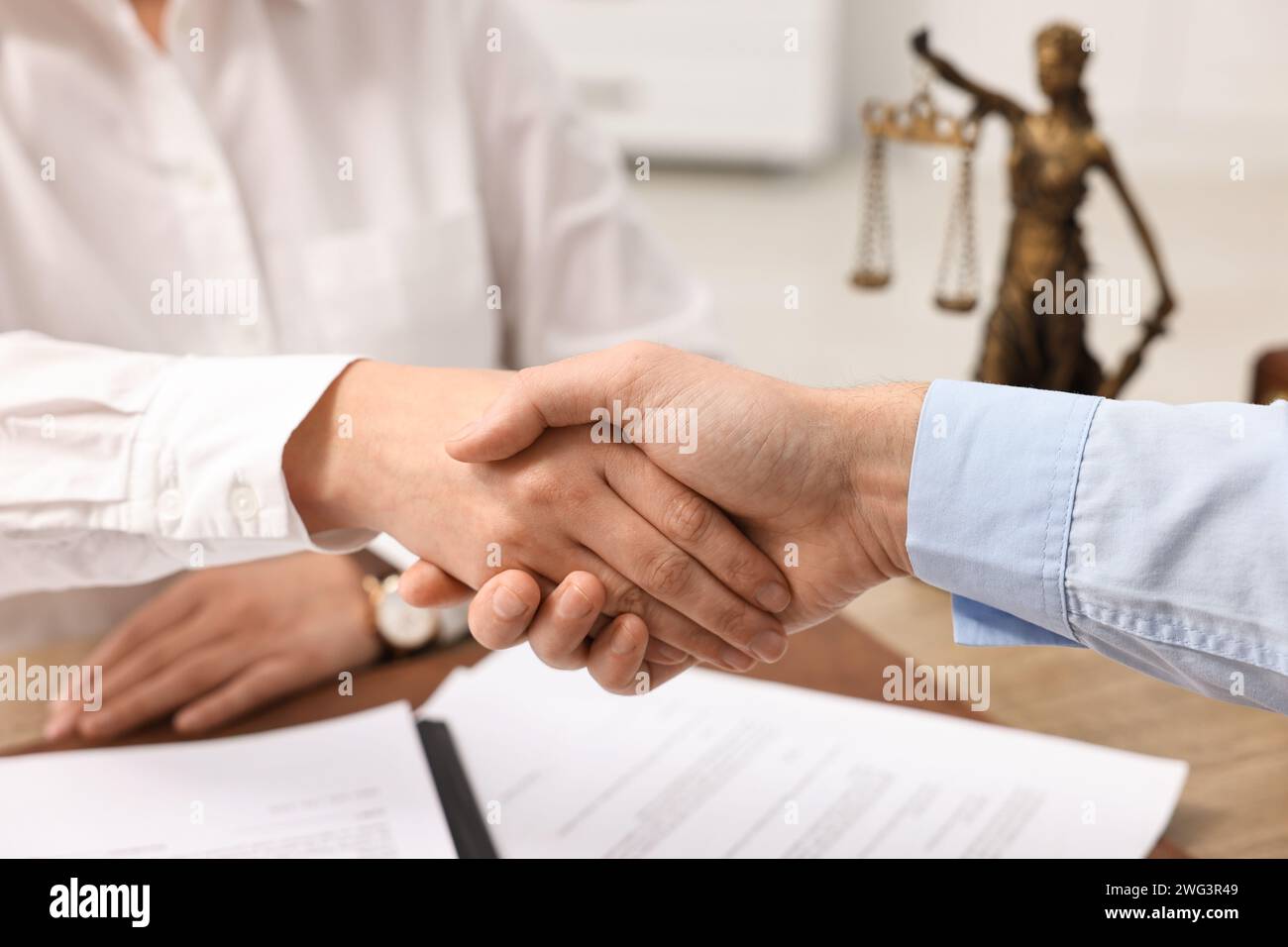Lawyers shaking hands at table in office, closeup Stock Photo - Alamy