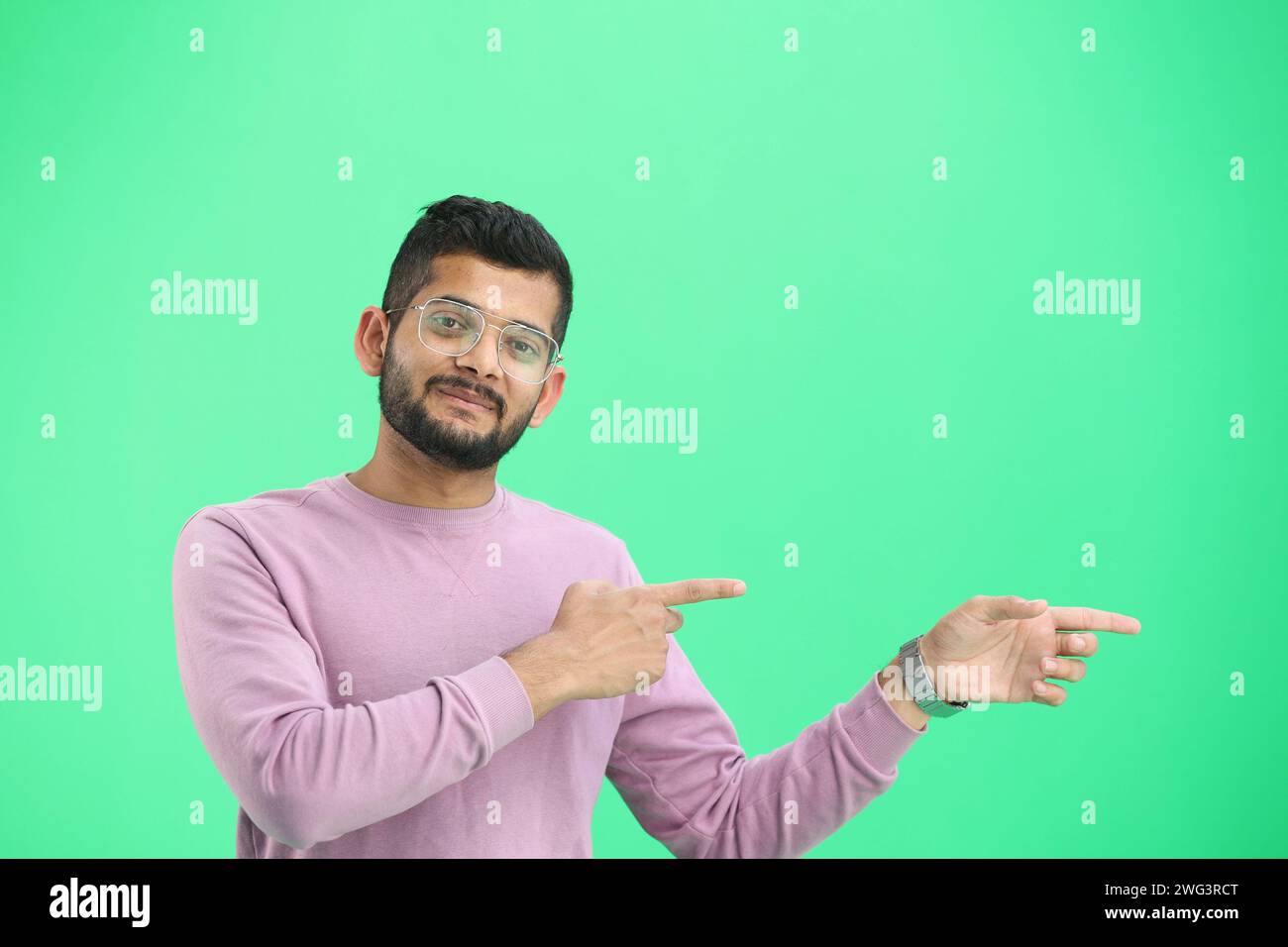 A man, on a green background, in close-up, points to the side Stock ...