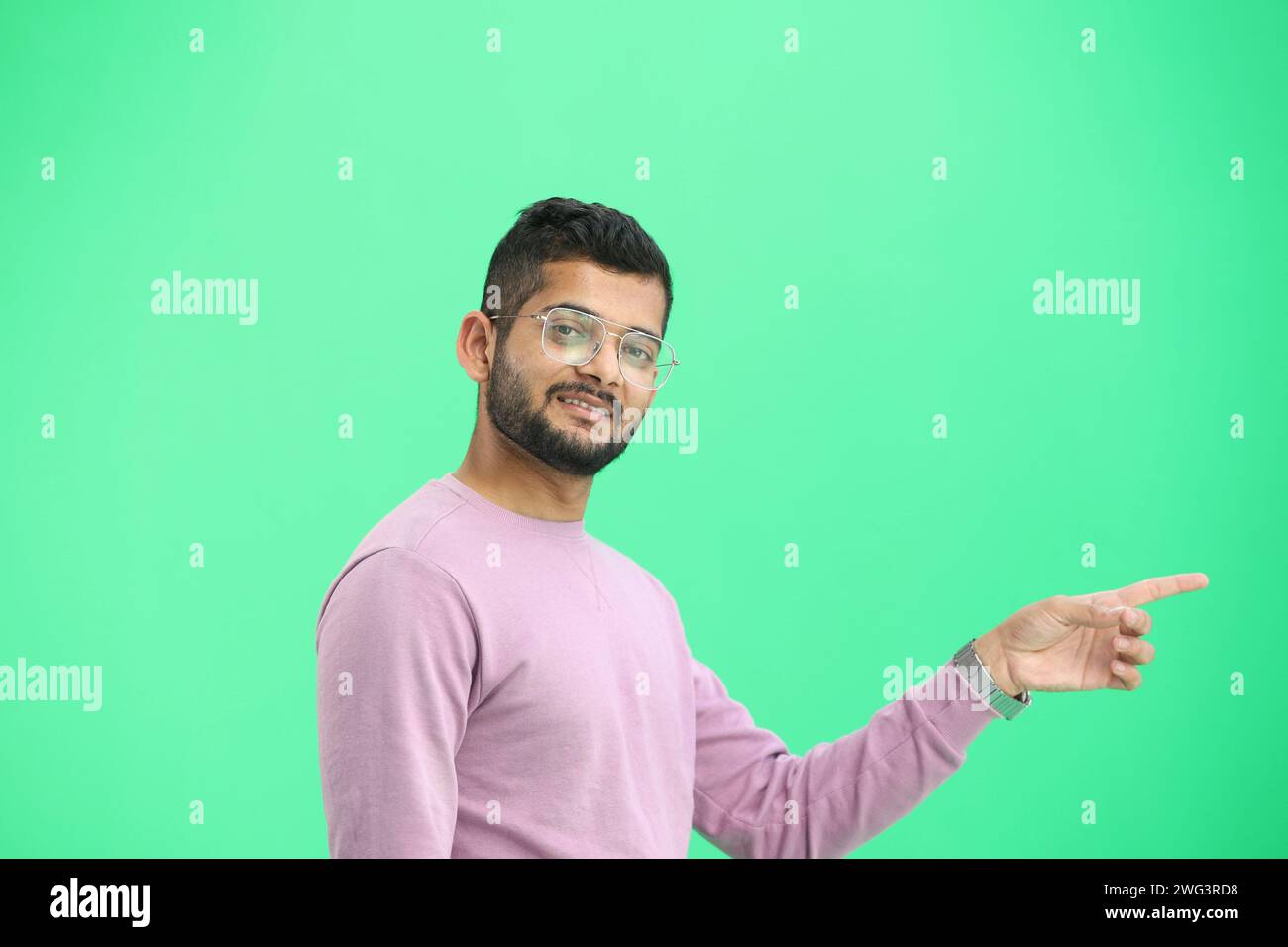 A man, on a green background, in close-up, points to the side Stock ...