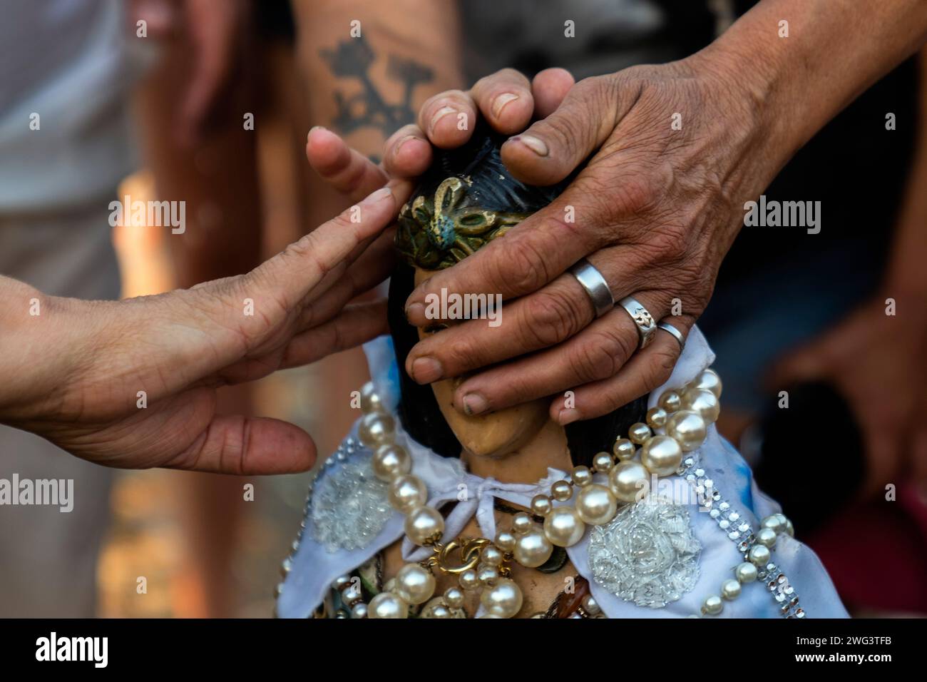 Devotees touch a statue of Yemanja as they participate in a ritual ...