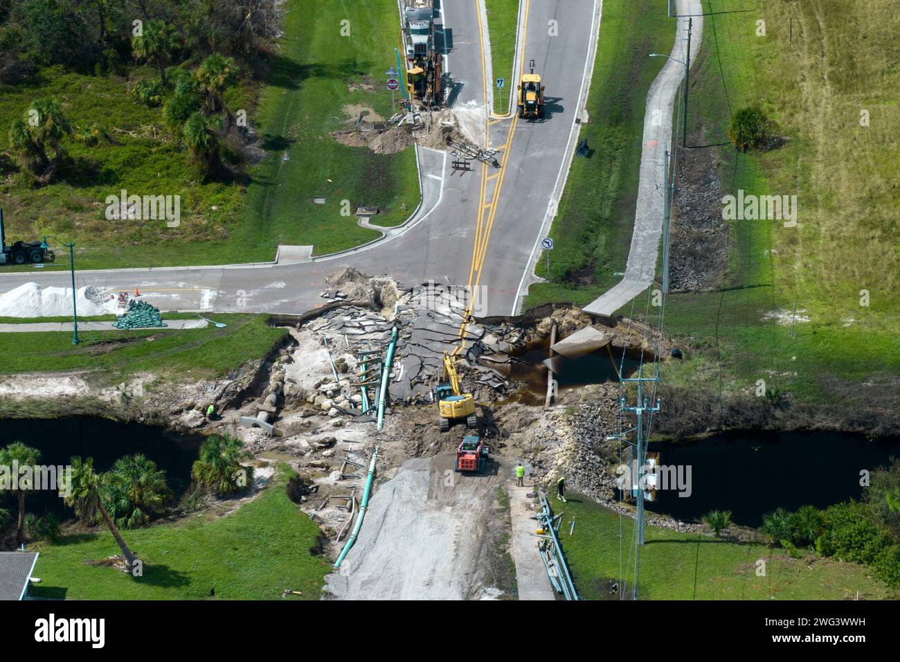 Road construction. Excavator repairing destroyed bridge after hurricane ...