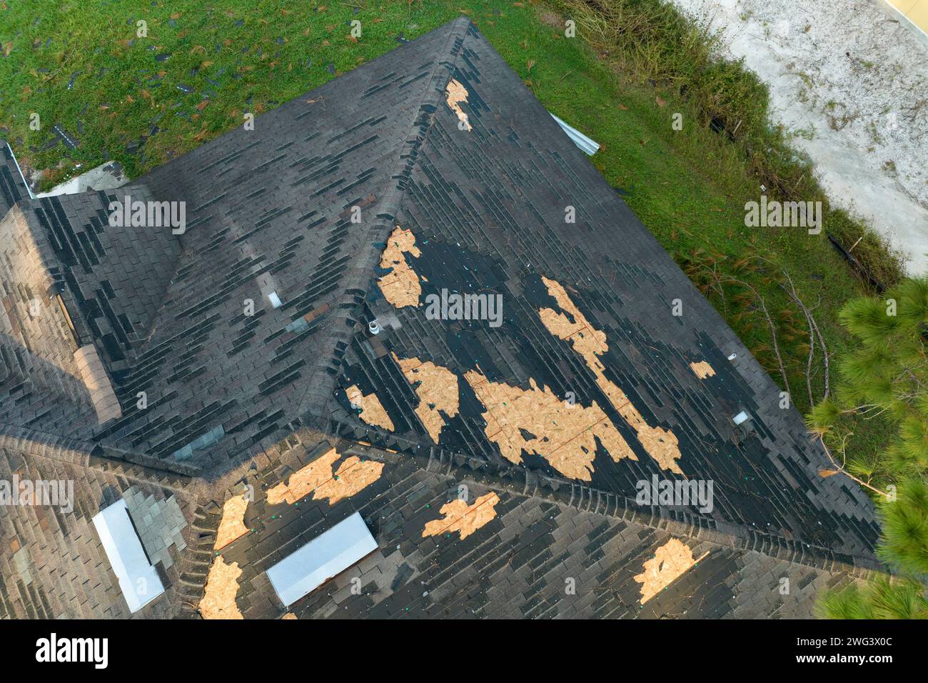 Damaged house roof with missing shingles after hurricane Ian in Florida ...