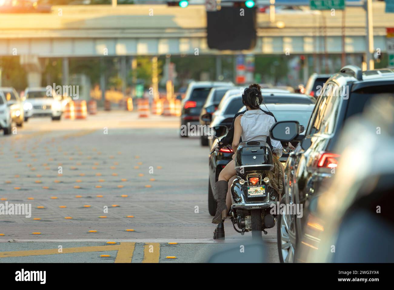 American street with driving motorcycle and cars at intersection with ...
