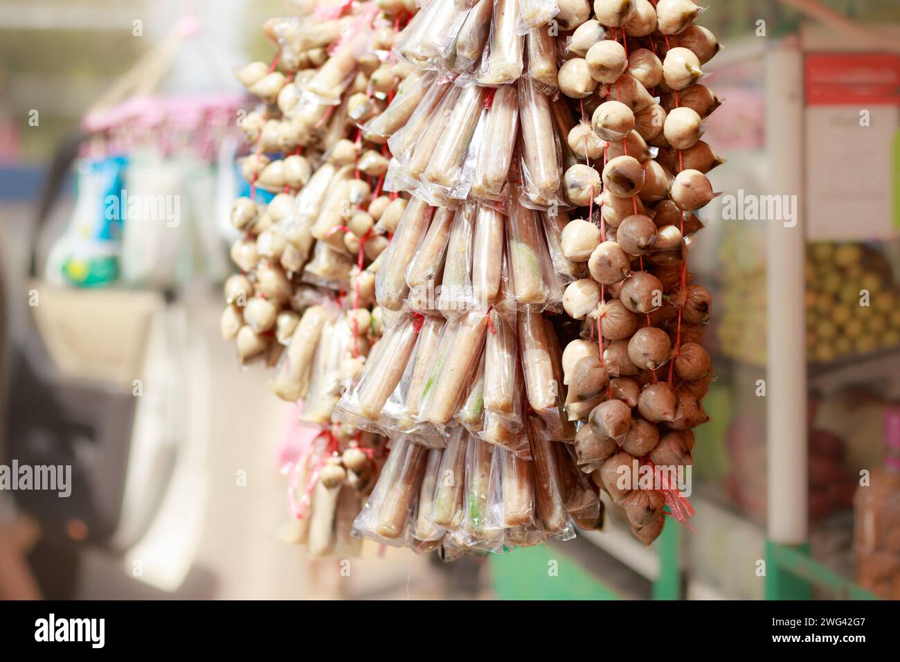 Packets of fermented pork called naem hanging at a local market in ...