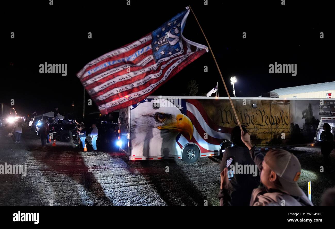 A man waves a flag as a "Take Our Border Back" convoy arrives in ...