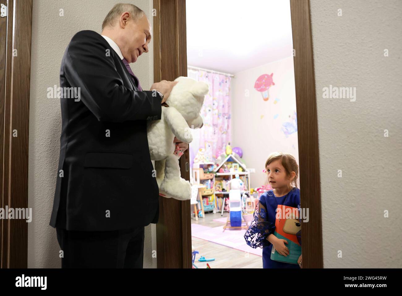 Russian President Vladimir Putin presents a teddy bear to Polina Shvetsova, daughter of the Tula ...