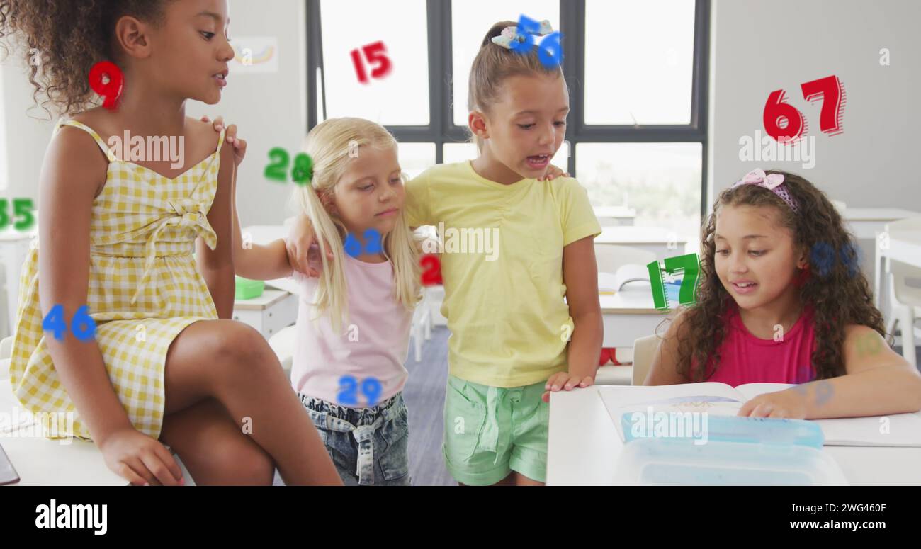Image of numbers over happy diverse schoolgirls talking in classroom ...