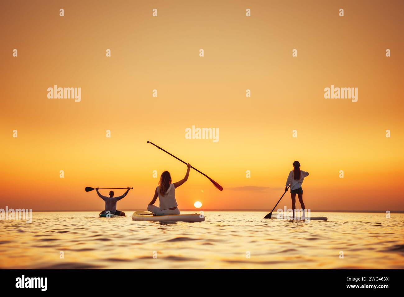 Group of happy young friends are relaxing with stand up paddle sup ...