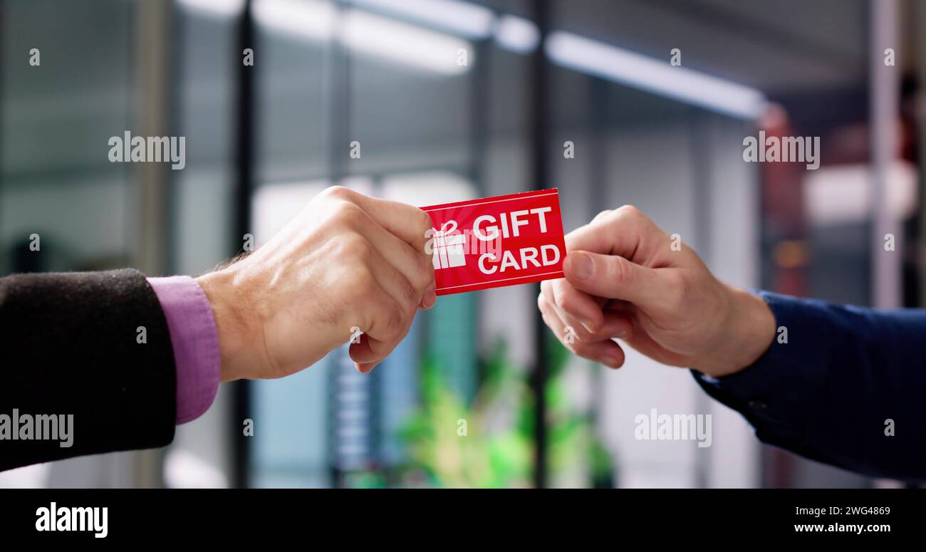 Hand Giving Gift Voucher Card. Holding Prepaid Coupon Stock Photo - Alamy