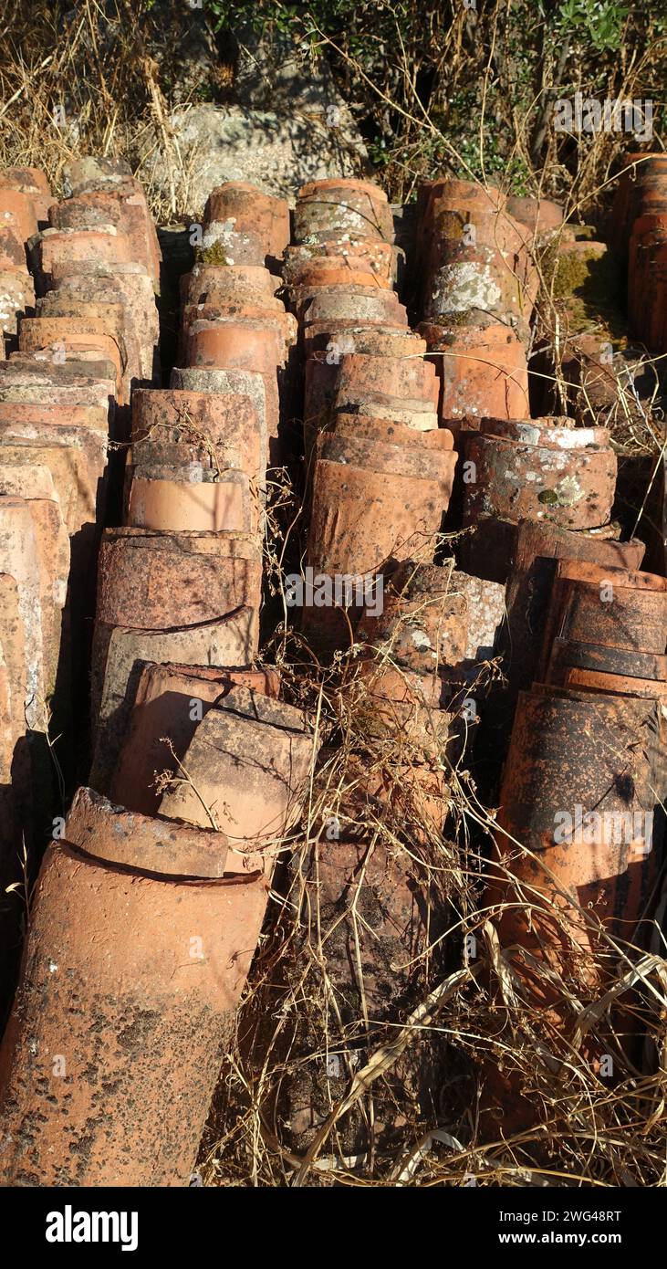 Hundreds of antique roof tiles piled in a row ready to be used for a ...