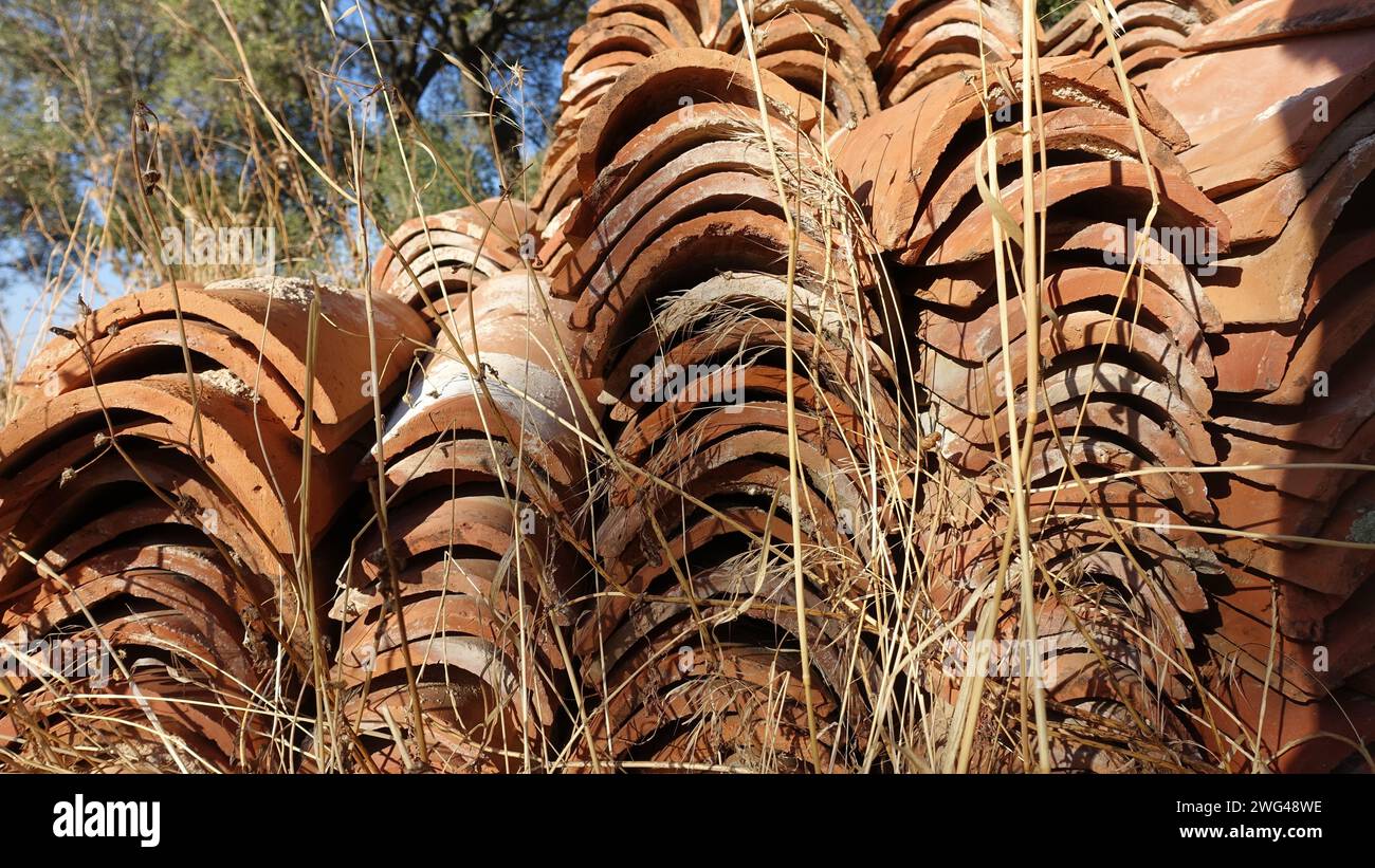Hundreds of antique roof tiles piled in a row ready to be used for a ...