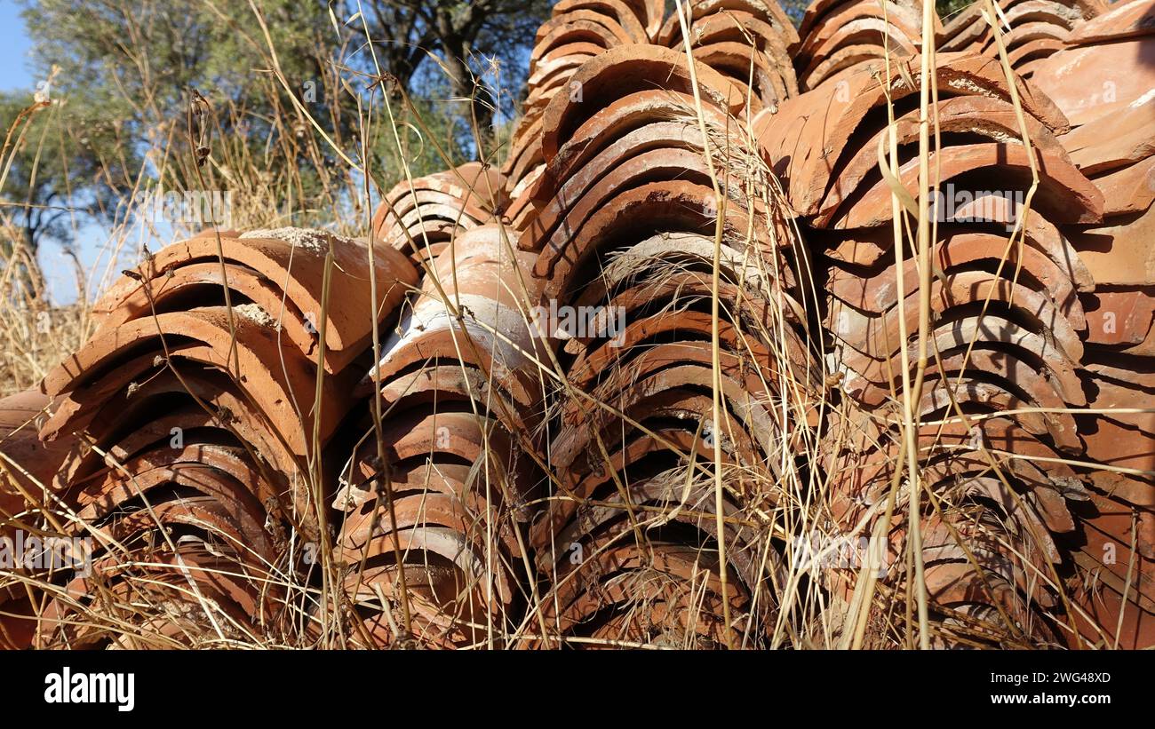 Hundreds of antique roof tiles piled in a row ready to be used for a ...