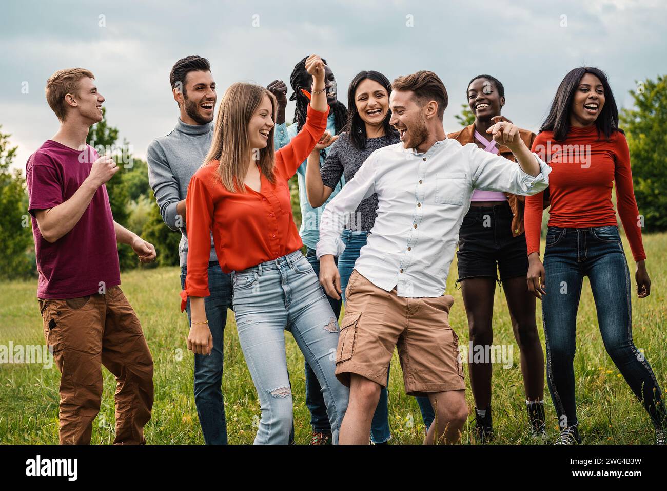 A vibrant group of young adults from various ethnic backgrounds shares ...