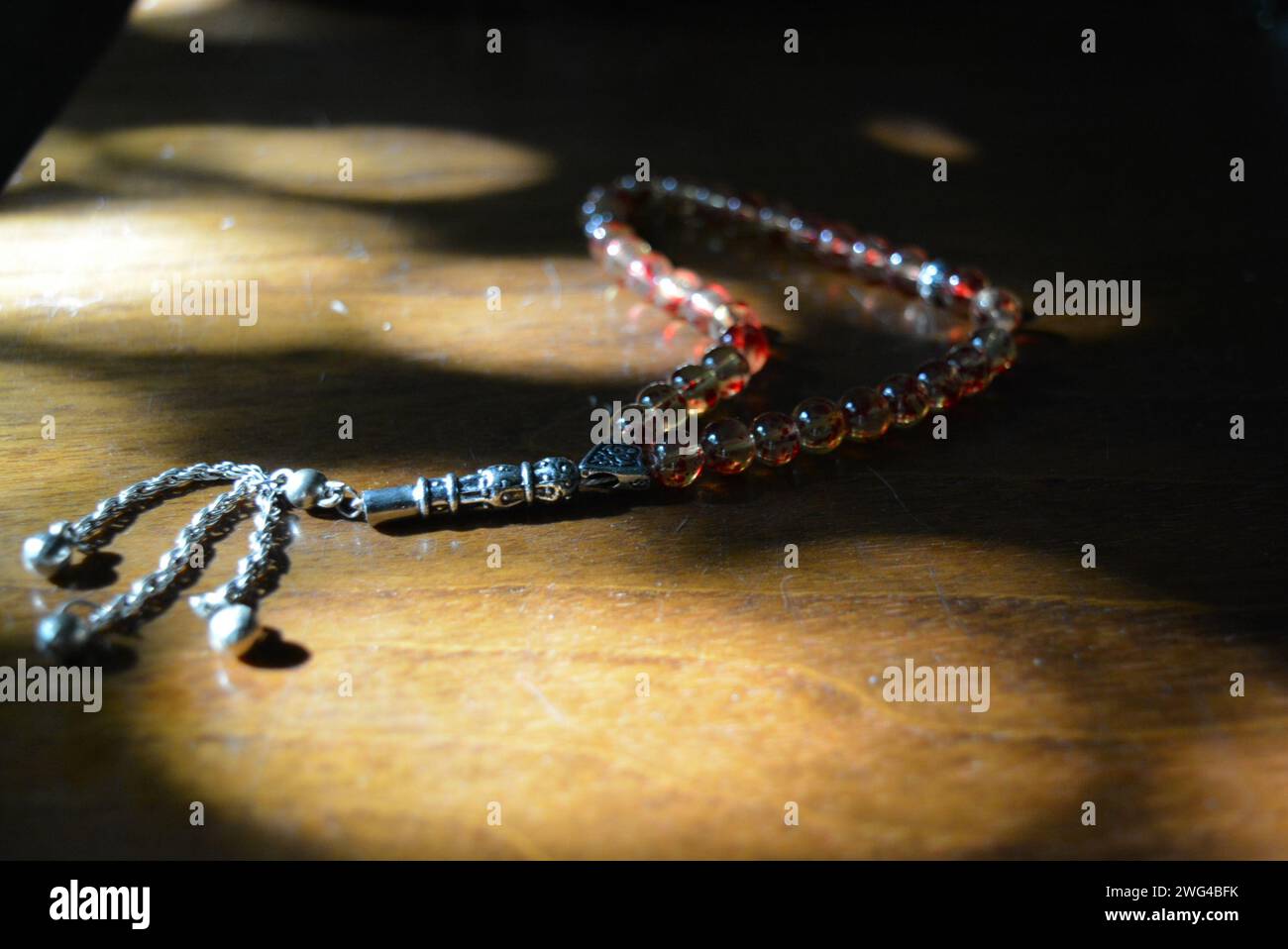 Muslim religious beads of yellow and red beads on a lacquered wooden ...
