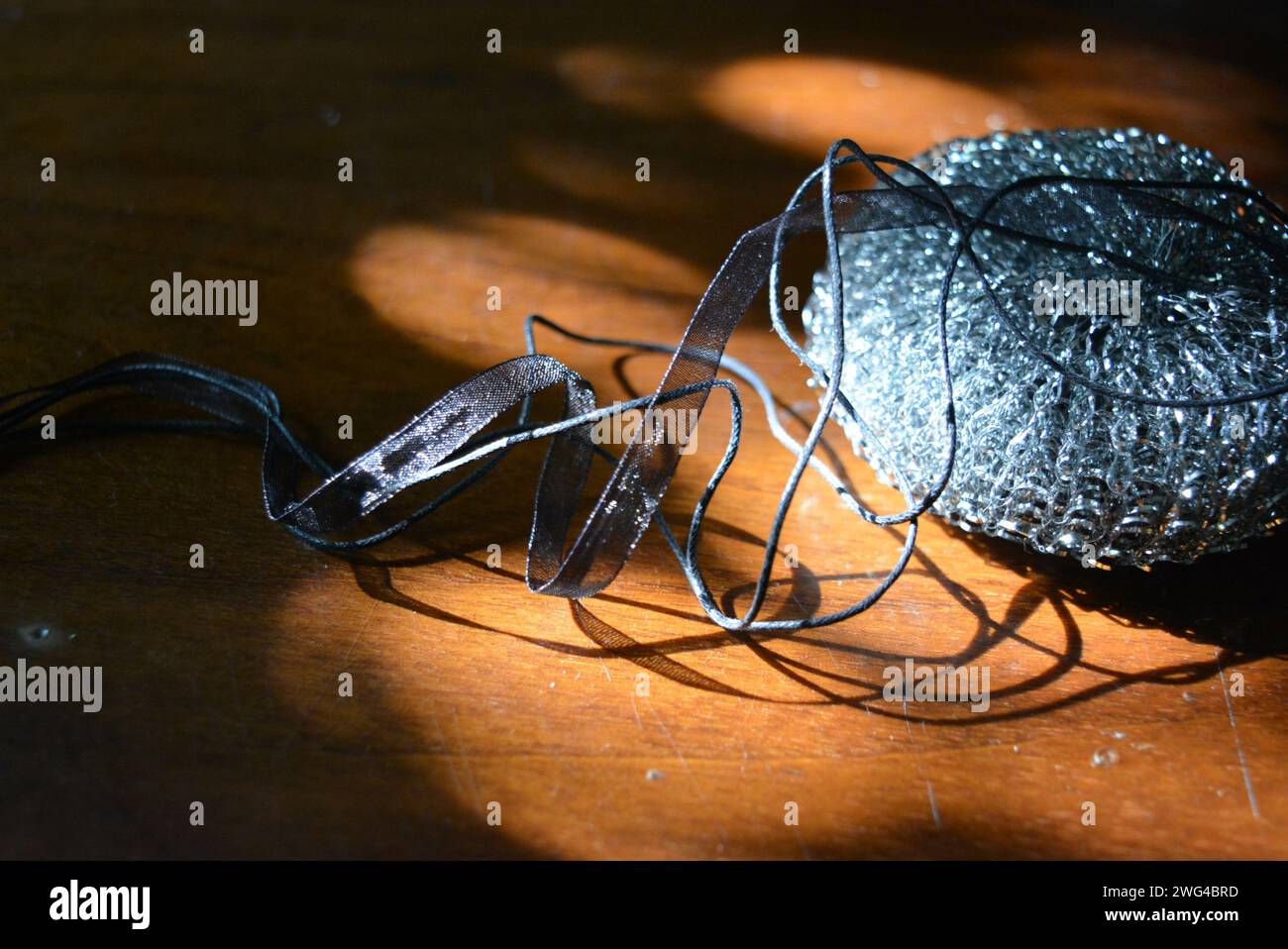 Metal sponge with a transparent black ribbon and black threads on a ...