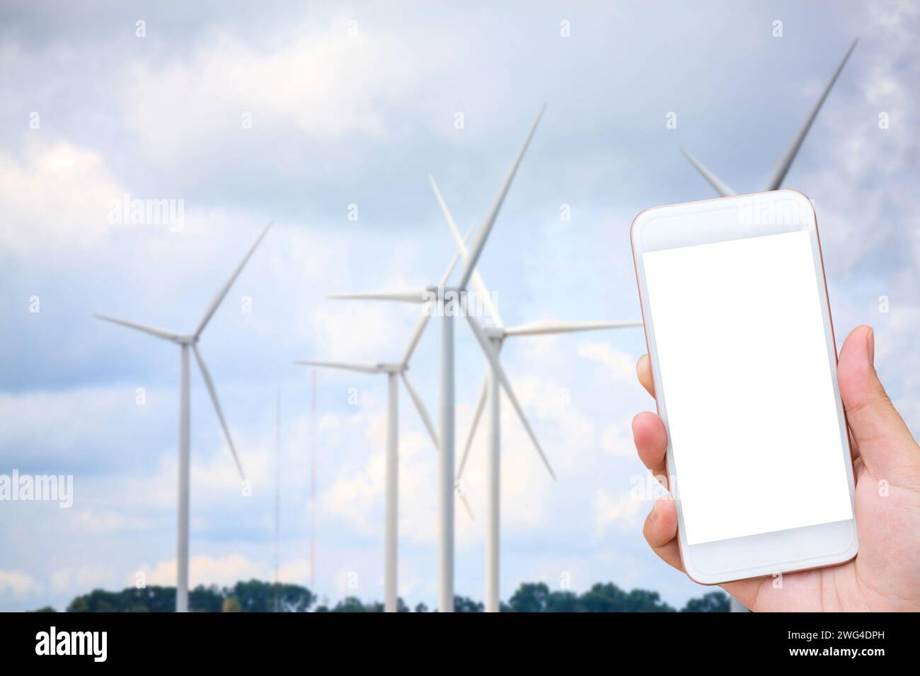 hand holding mobile phone with wind turbines background, renewable ...