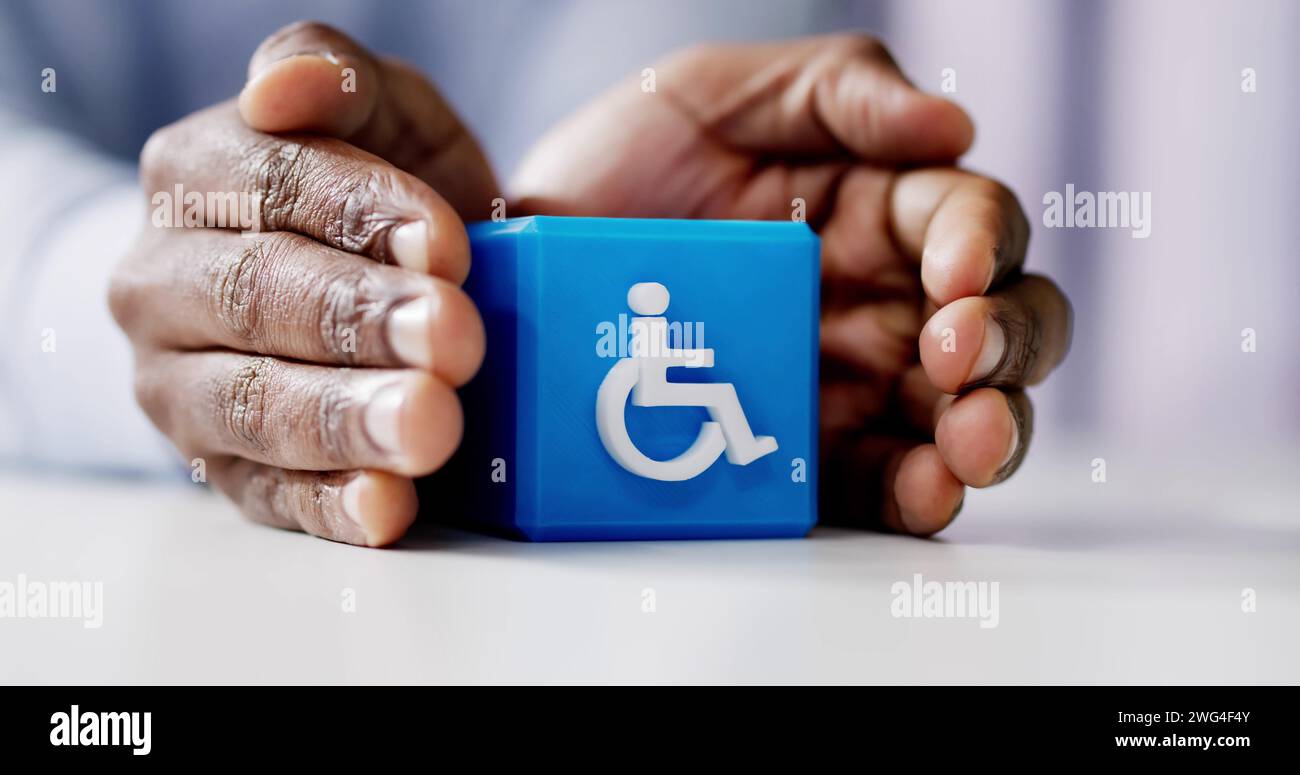 Person's Hand Protecting Blue Cubic Block With Disabled Icon Stock ...