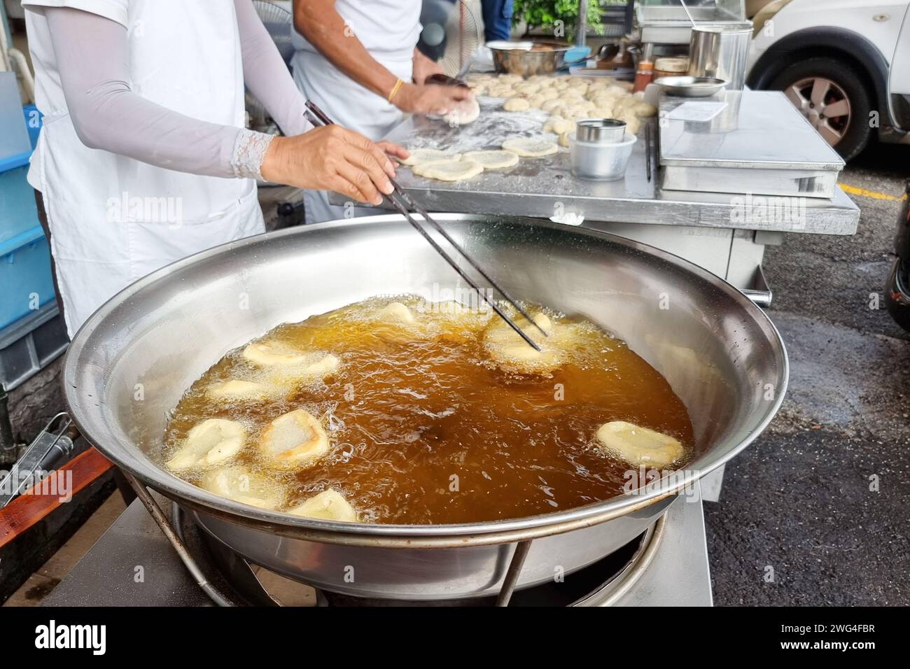 Hawker deep frying the Ham Chim Peng in wok with hot oil, a popular ...