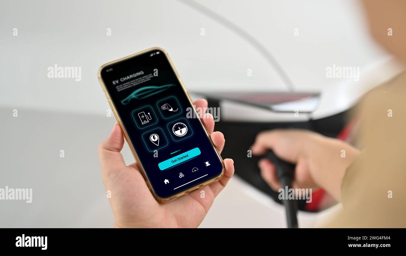Man using EV application on his phone to check charging status while ...