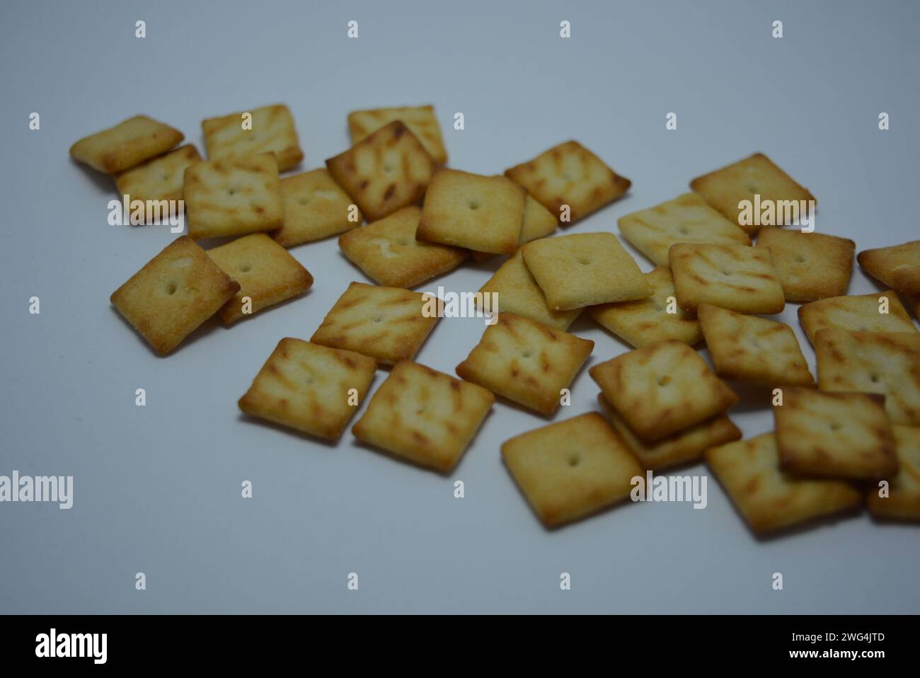 Salty, delicious, and crispy, small, square crackers scattered all over ...