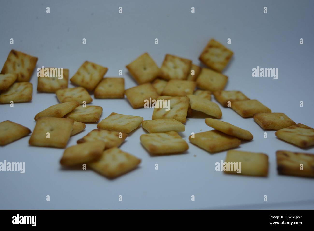 Salty, delicious, and crispy, small, square crackers scattered all over ...