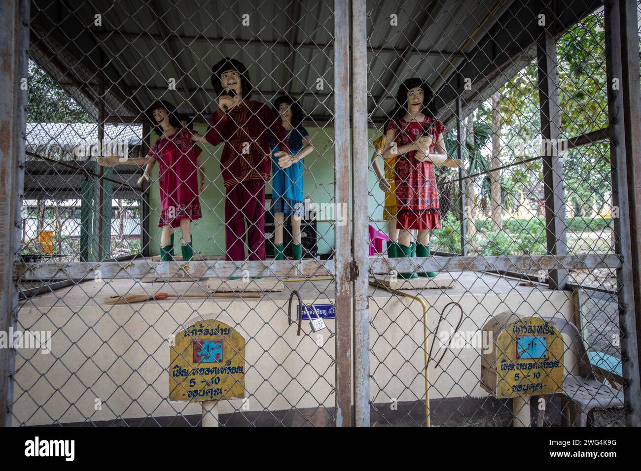Human mock-up statues singing inside a cage at the Wat Tham Pla Temple ...