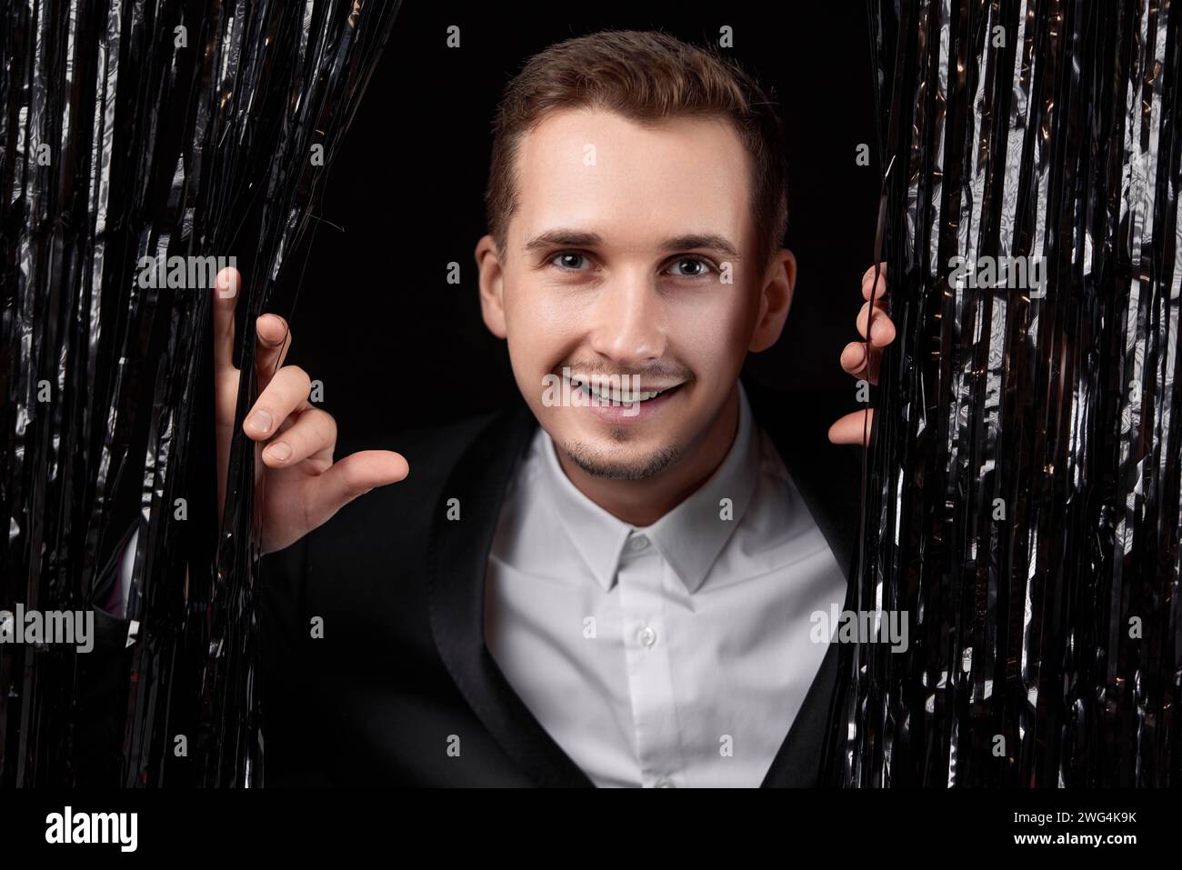 Happy handsome man in black jacket smiling on glitter background Stock ...