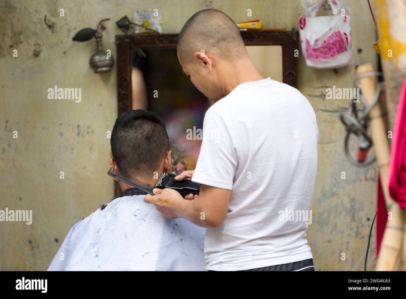 Vietnam, Hanoi, street barber trimming hair Stock Photo - Alamy