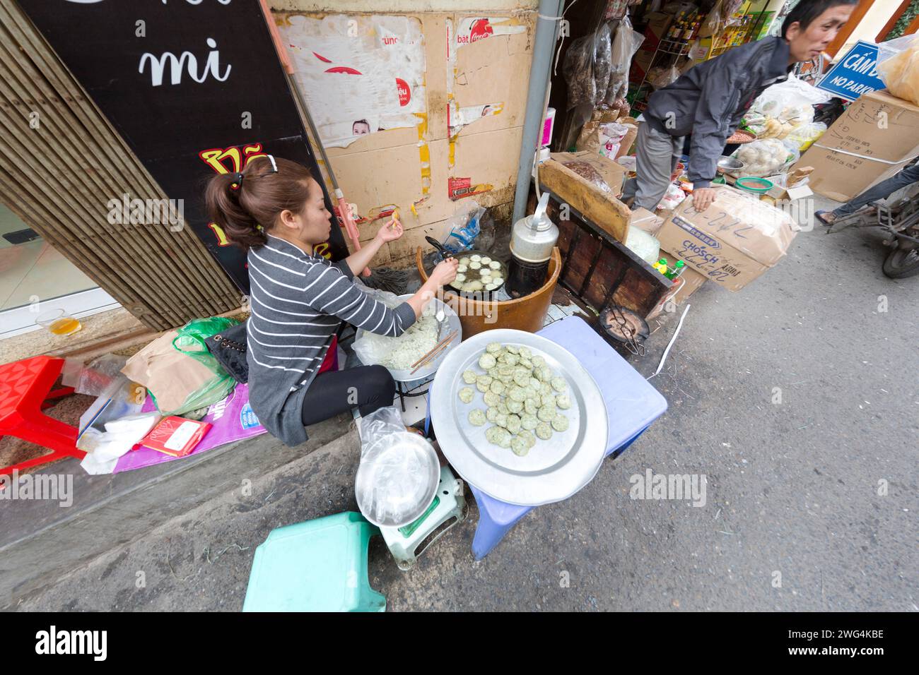 Vietnam, Hanoi, street vendor preparing and cooking food on the ...