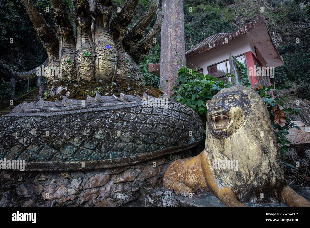 A lion sculpture at the beginning of the stairs leading to a cave at ...