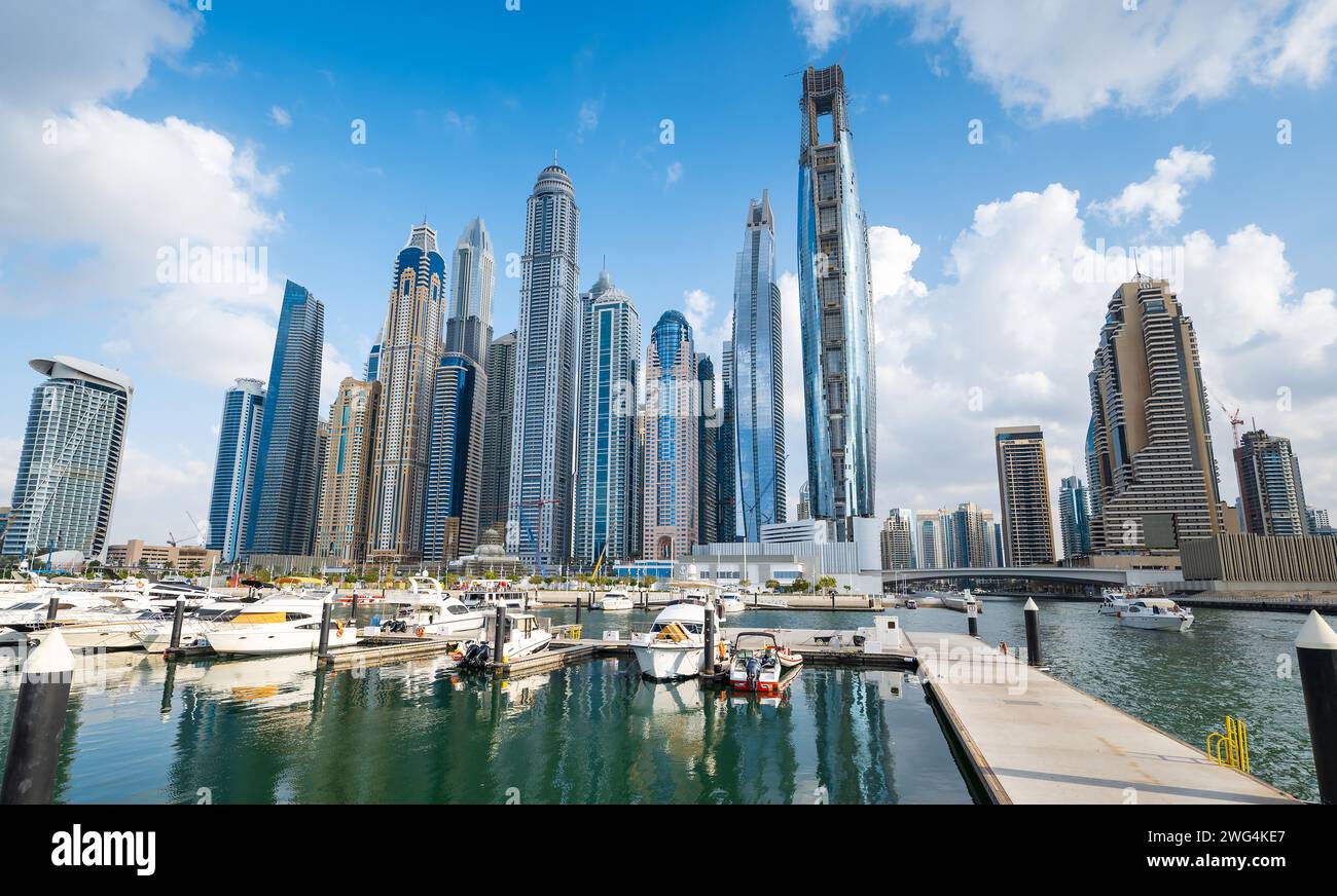 Dubai marina harbor on a sunny day in the UAE with a bustling ...