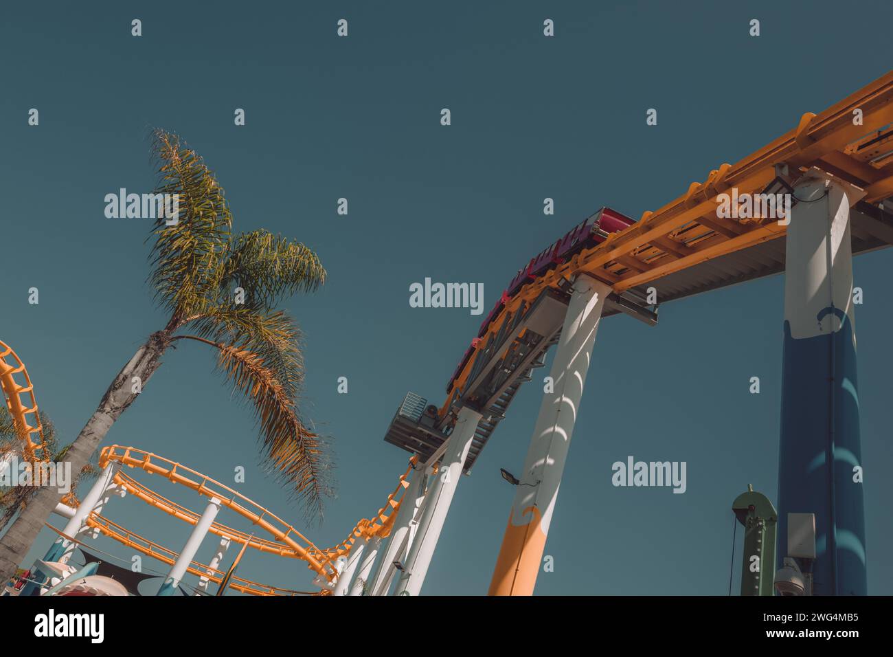 Moving roller coaster in an amusement park during the summer daytime ...
