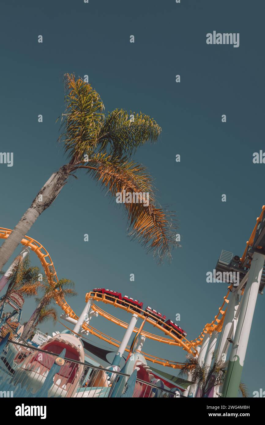 Moving roller coaster in an amusement park during the summer daytime ...