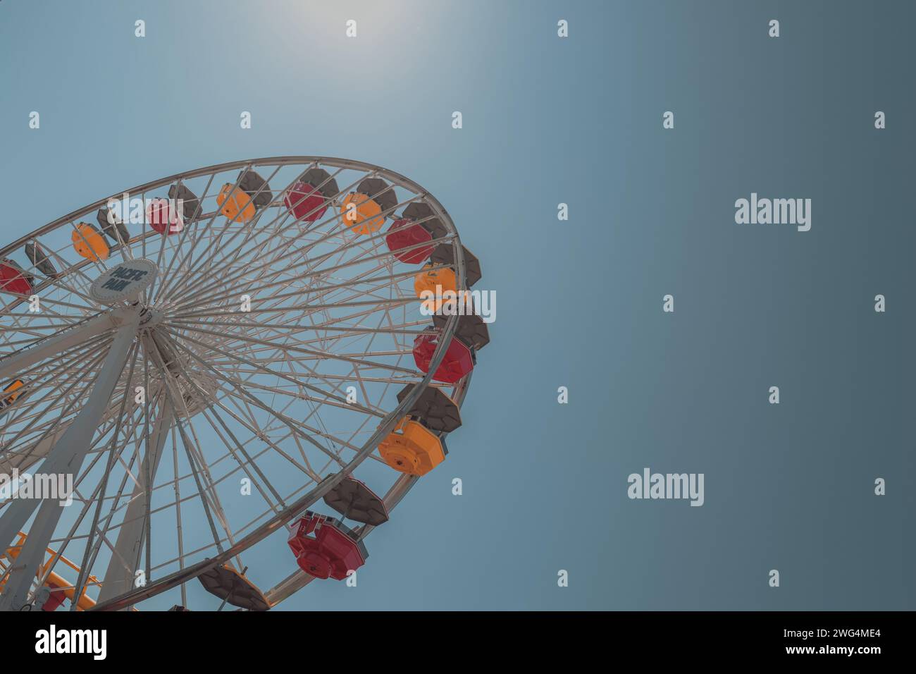 Moving Ferris wheel in an amusement park during the summer daytime ...