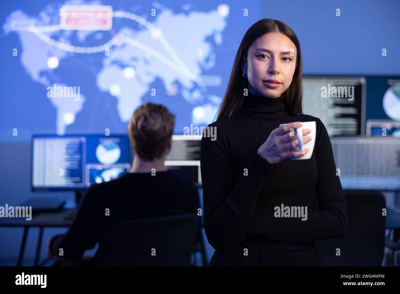 Professional Female IT Consultant holding coffee cup in large Cyber ...