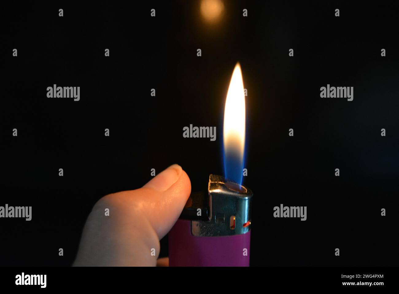 The fire and the included pink plastic lighter lie in a female hand on ...