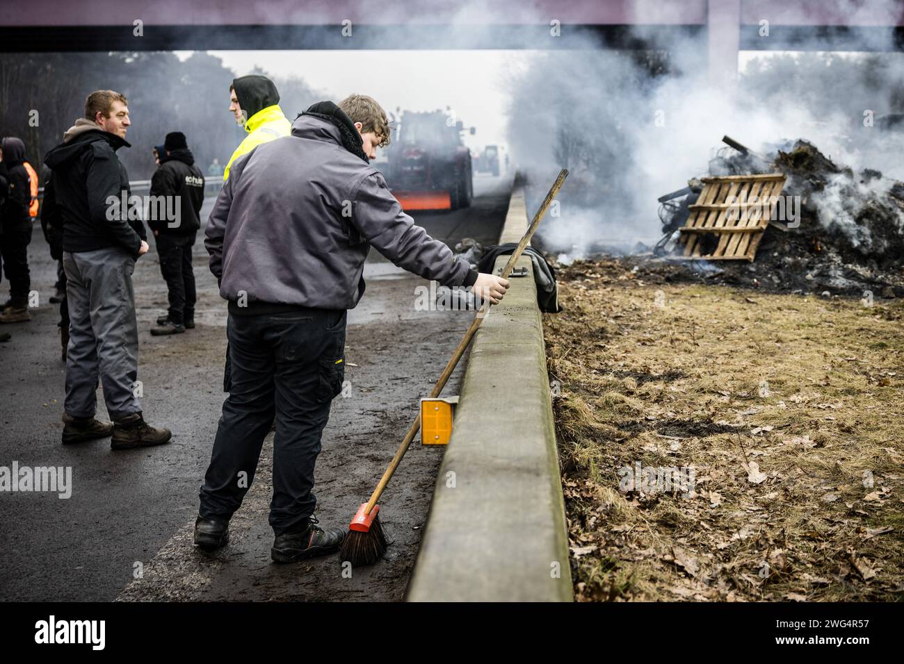 ARENDONK - Belgian farmers clean the road surface while blocking the ...