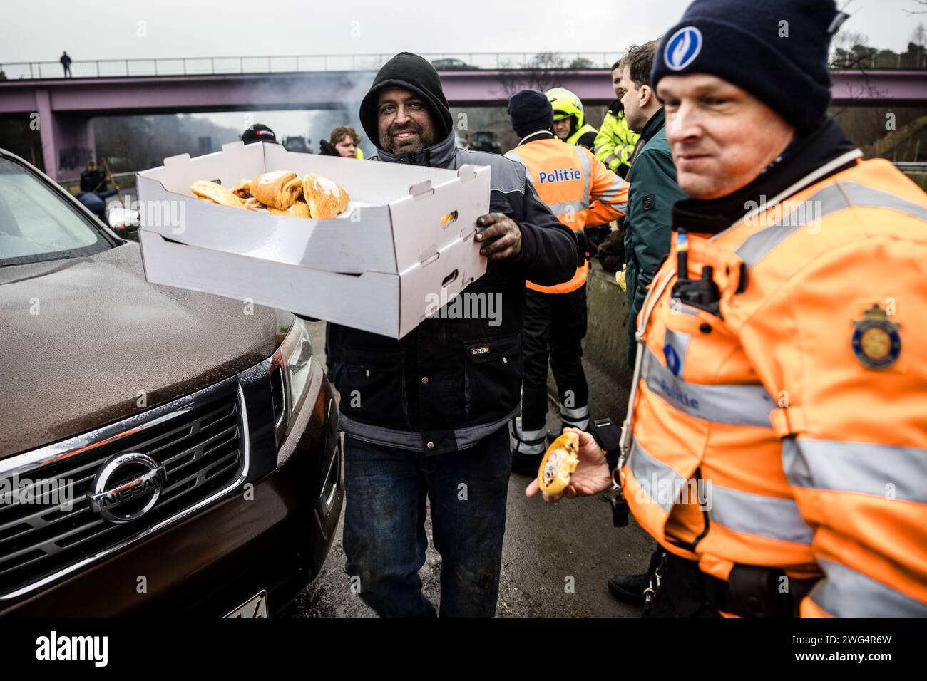 ARENDONK - Belgian farmers clean the road surface while blocking the ...