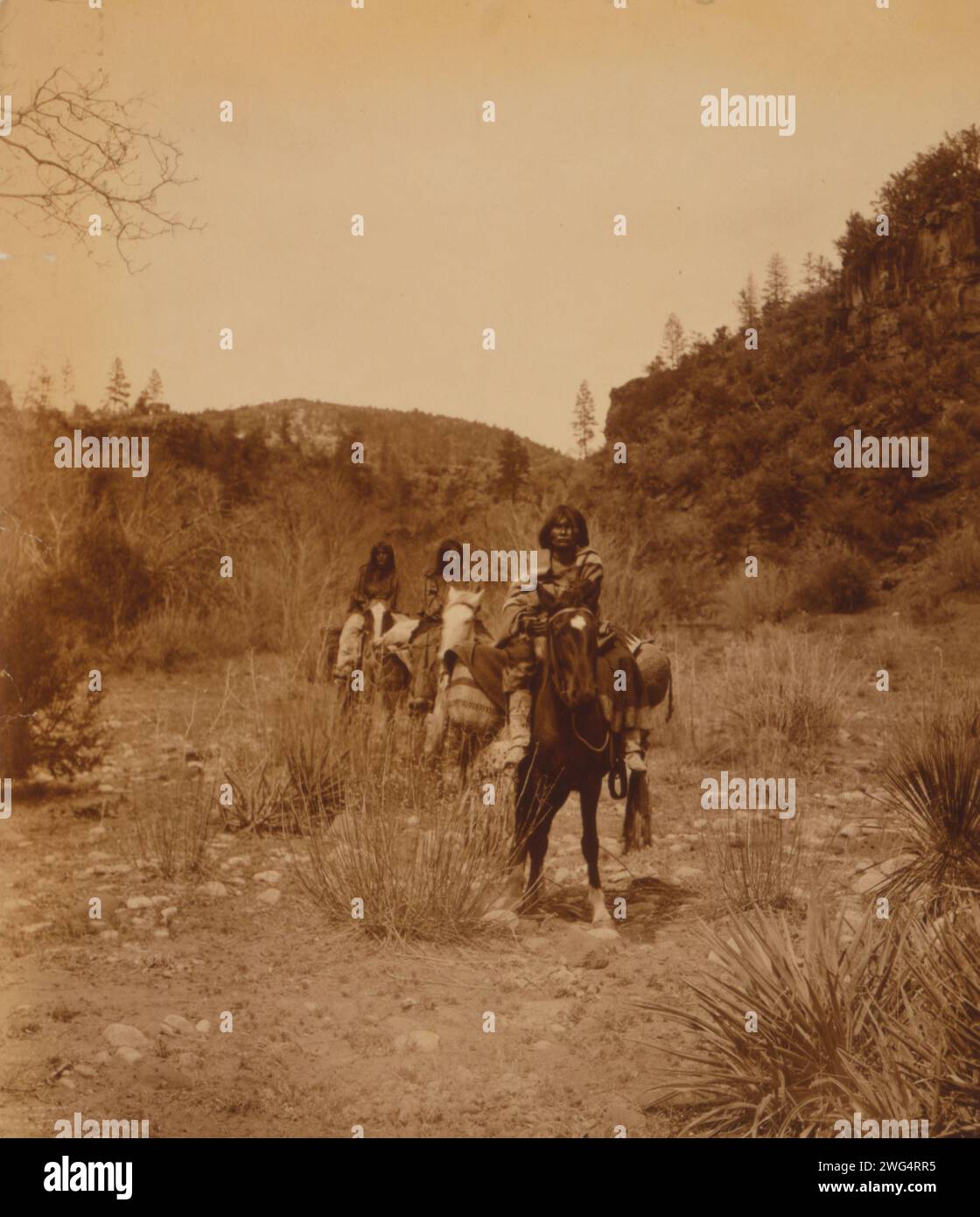 Apache land, c1903. Three Apache people riding pack horses make their ...