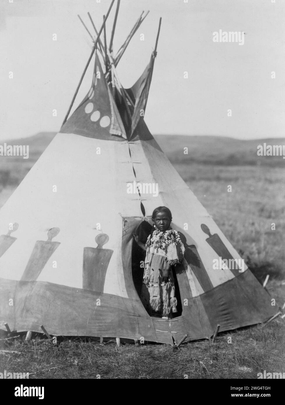 Crow Chief's Daughter, c1910. Piegan girl standing in doorway of tepee ...