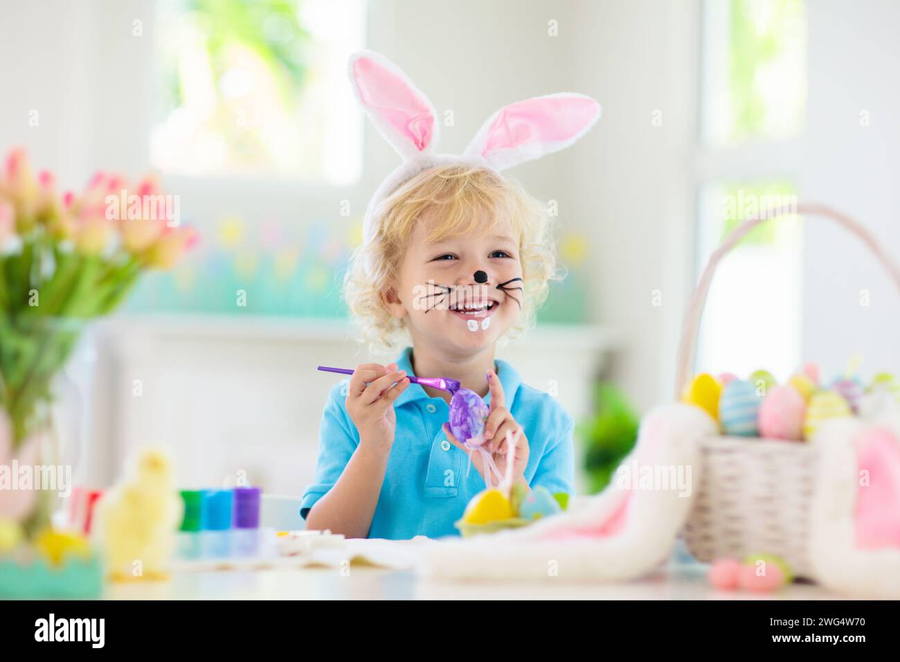Kids dyeing Easter eggs. Children in bunny ears dye colorful egg for ...