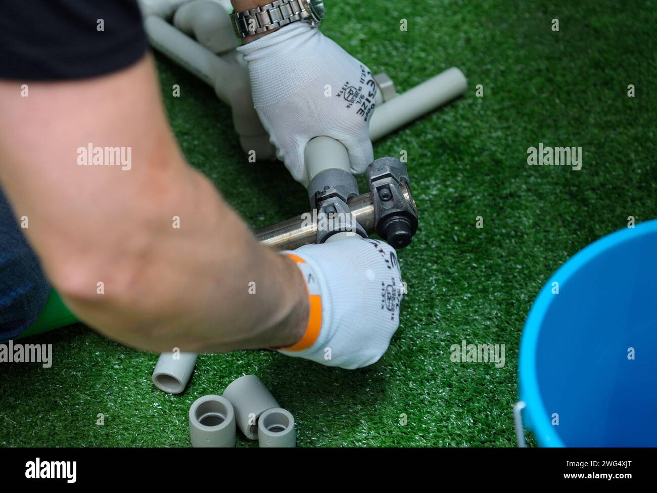 Plumber hands in gloves joining plastic pipes with the soldering iron ...
