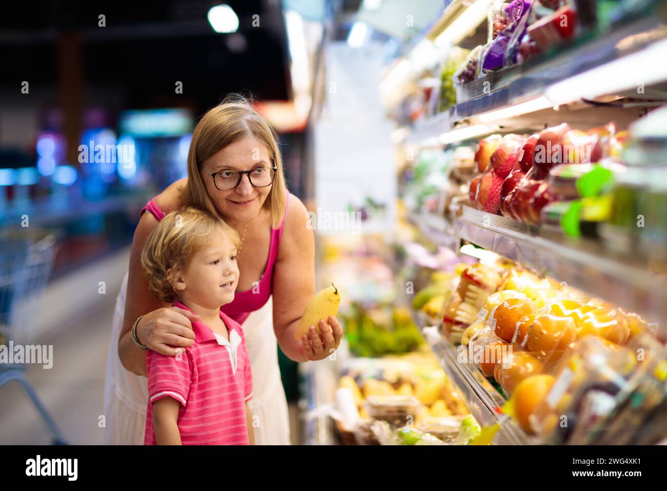 Shopping with kids. Mother and child buying fruit in supermarket. Mom ...