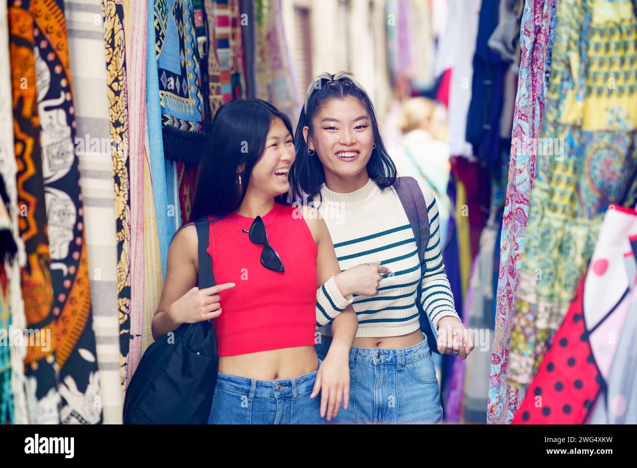 Two Asian female tourists shopping clothes in street bazaar Stock Photo ...