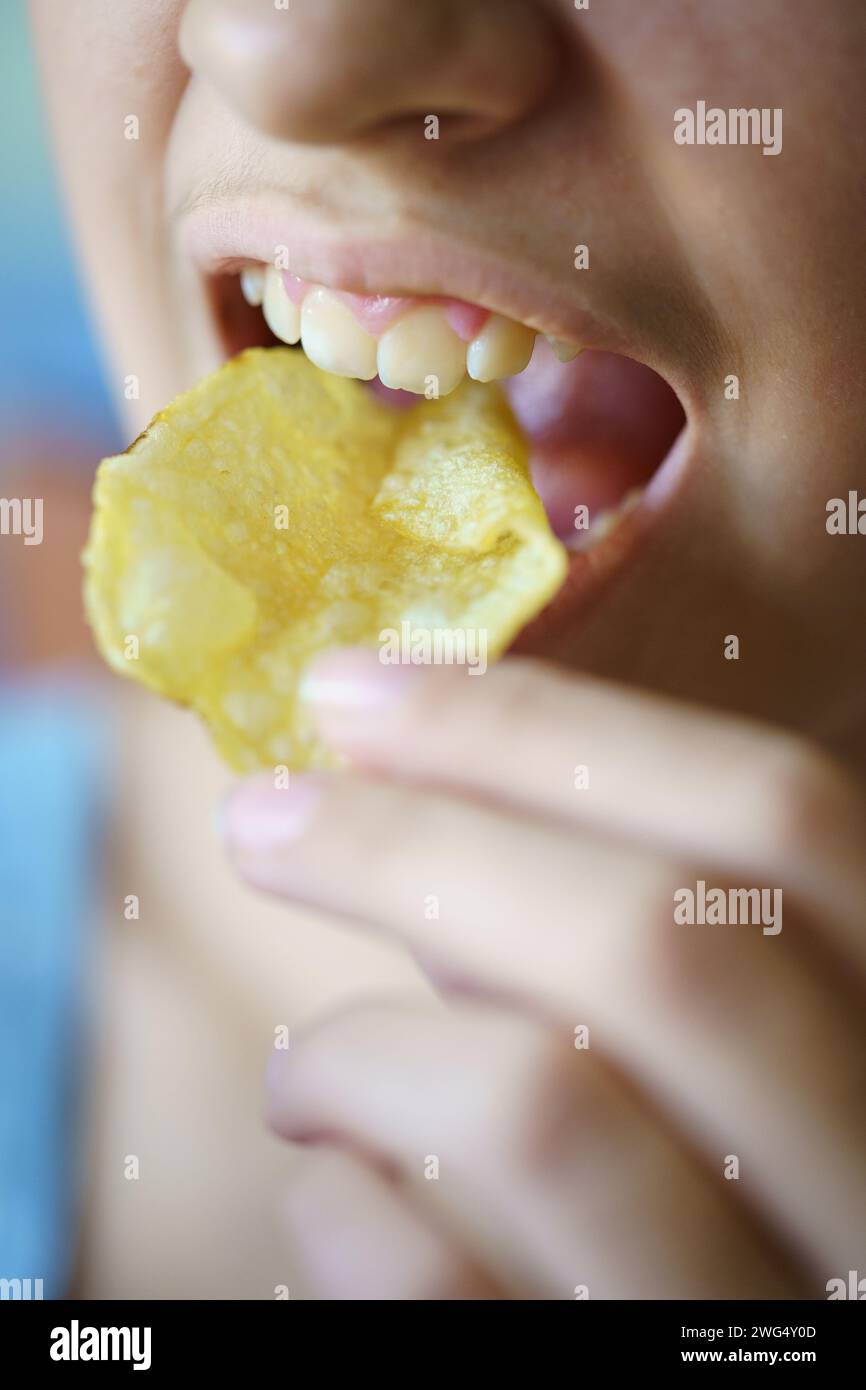 Unrecognizable teenage girl eating crunchy potato chip Stock Photo - Alamy