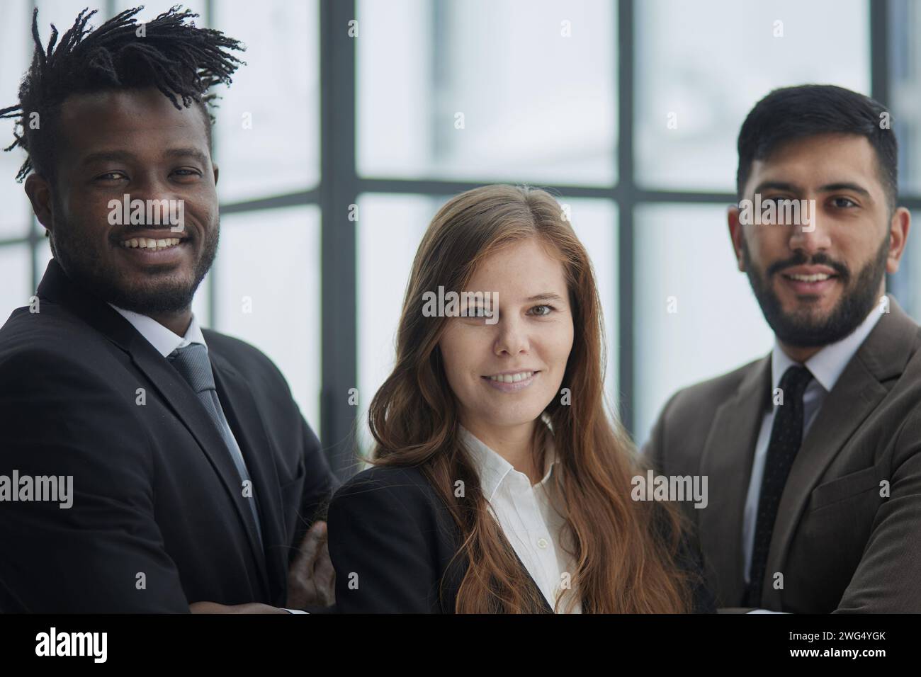 a group of three employees posing together with their arms crossed ...