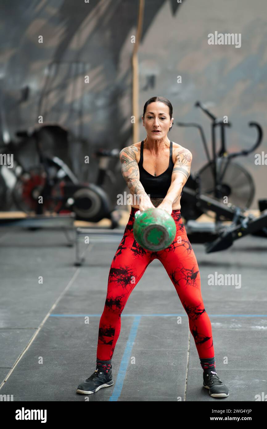 Woman performing kettlebell swing exercise in a gym Stock Photo - Alamy