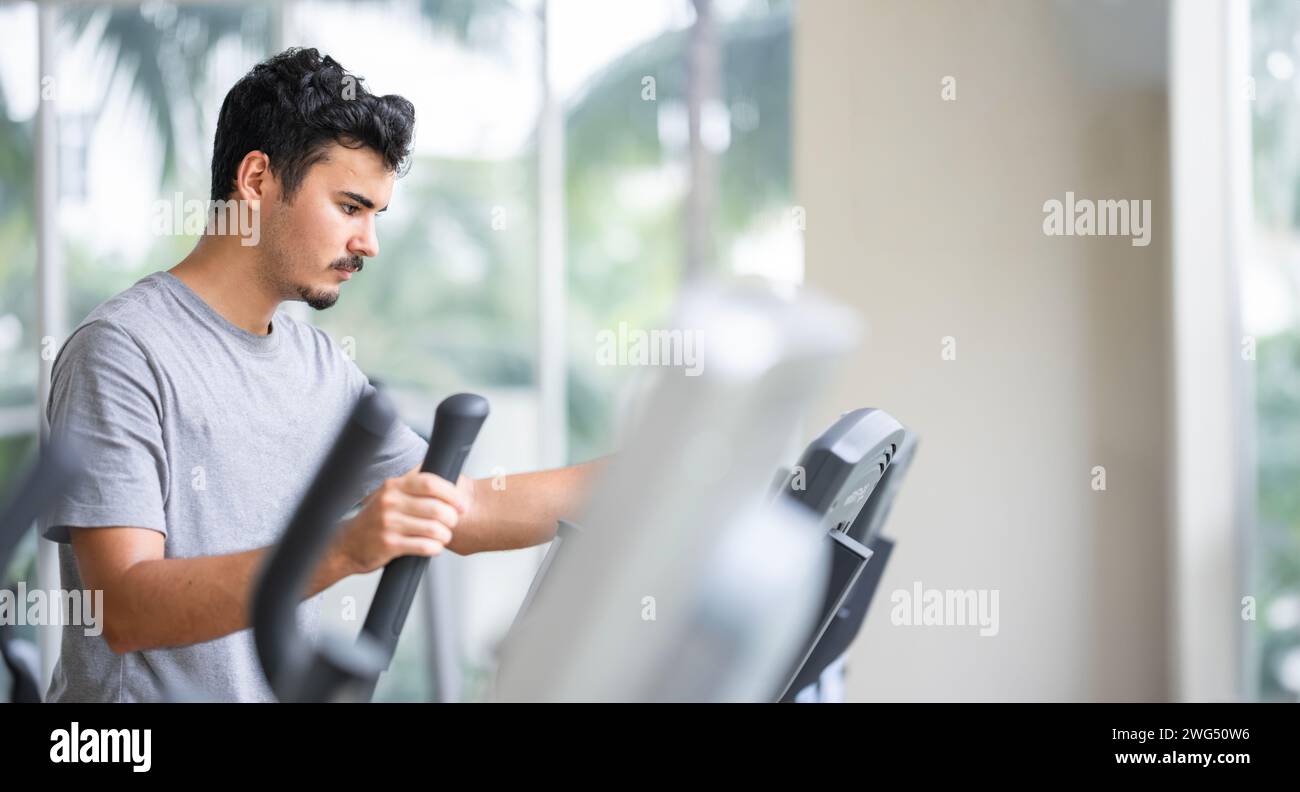 Focused individual using a cardio machine, demonstrating the dedication ...