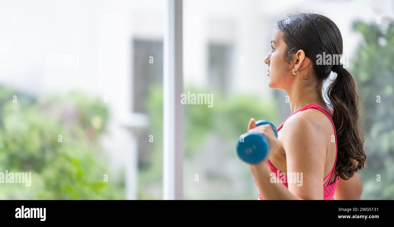 Focused and determined, a young woman engages in a fitness routine ...