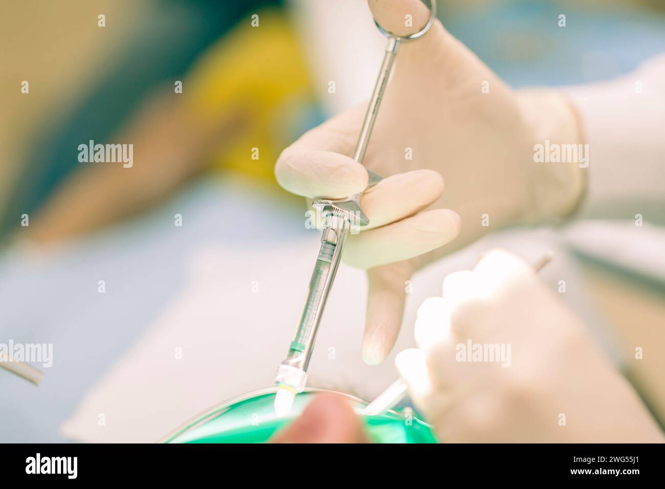 Detail of a dentist performing surgery with anesthesia on a patient for root canal treatment and ...